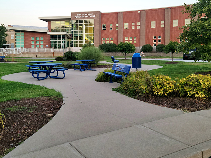 Moline's Police Department building balances authority with accessibility, its modern design suggesting transparency while blue benches invite community connection.