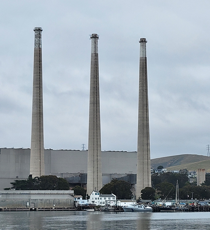 The power plant's three stacks stand as industrial sentinels, an unexpected contrast to the natural beauty surrounding them.
