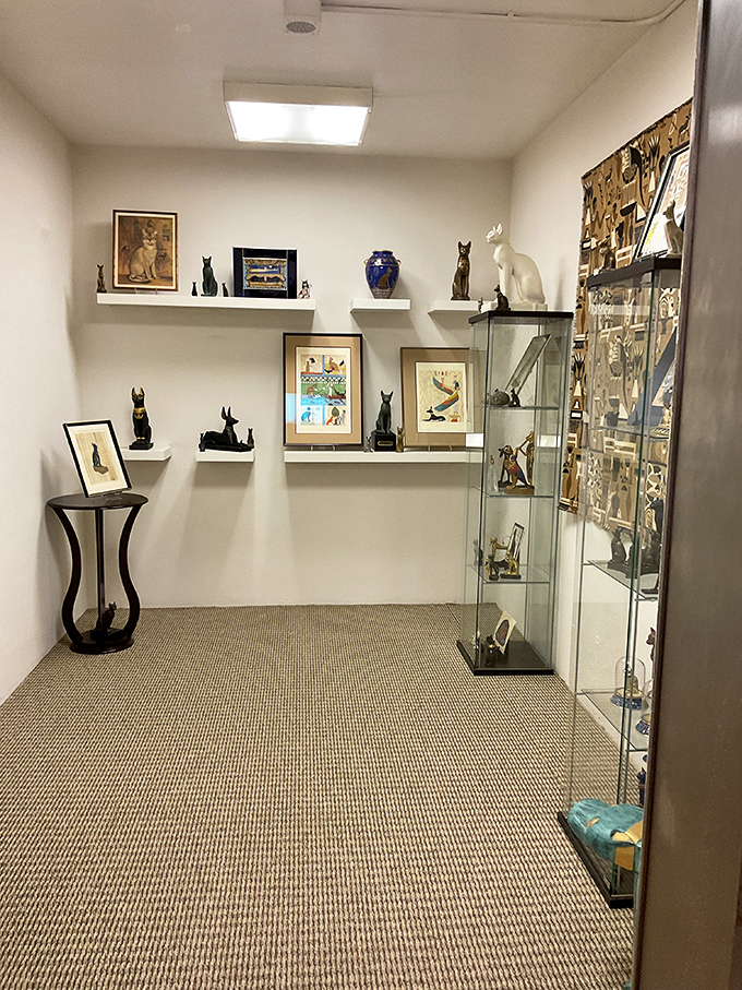 Egyptian-inspired cat statues share space with modern interpretations, showcasing how feline worship has evolved yet remained constant through millennia.