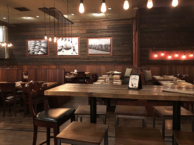 Edison bulbs cast a warm glow over reclaimed wood walls, creating an atmosphere that's simultaneously upscale and comfortably unpretentious.