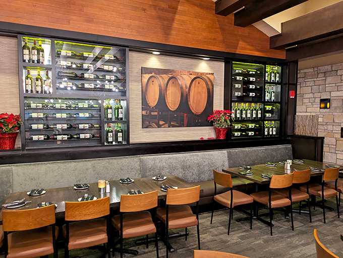 Wine bottles line the walls like soldiers standing at attention, ready for duty. The warm wood and stone create an atmosphere of rustic elegance.