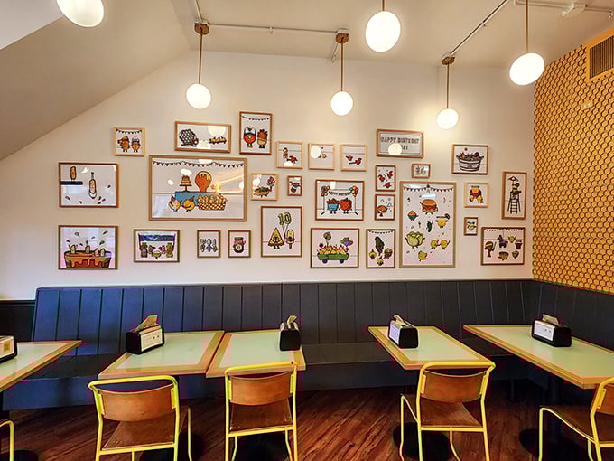 Whimsical food art adorns walls above cozy booths, creating a playful backdrop for serious eating business.