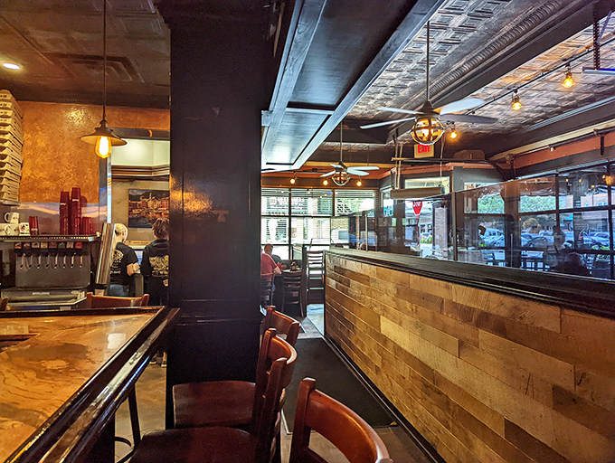 The bar area whispers, "Stay awhile." Wood paneling and warm lighting create the perfect backdrop for pizza-fueled conversations.