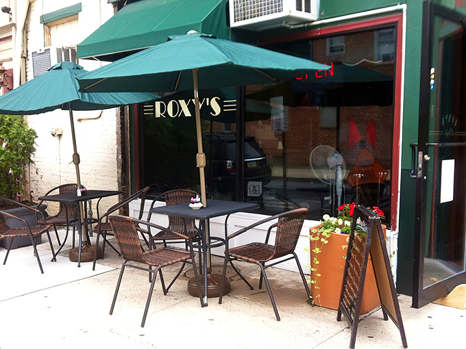 Outdoor seating under green umbrellas&mdash;because sometimes pancakes taste even better with a side of fresh air and people-watching.