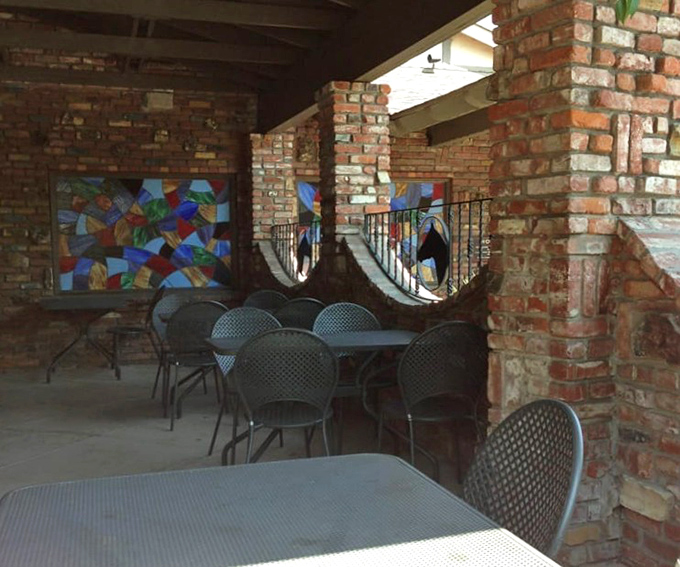 The outdoor patio offers a moment of California sunshine between courses, with stained glass adding unexpected pops of color.