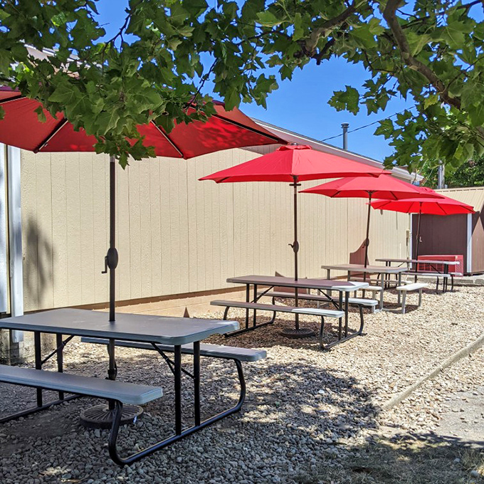 The outdoor patio with its cheerful red umbrellas offers shade for both your ice cream and your opinions about the neighbor's new fence.