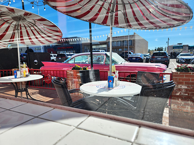 Outdoor dining with a side of classic car appreciation. Those red-and-white striped umbrellas provide shade for both your table and your Instagram ambitions.