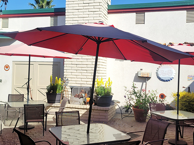 California sunshine meets comfort food on this charming patio. Red umbrellas provide shade while potted plants add a touch of garden-fresh ambiance.