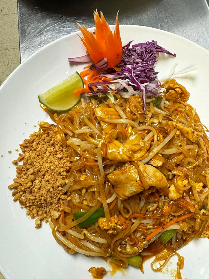 Pad Thai presented with architectural precision&mdash;crushed peanuts waiting to join the party, purple cabbage adding pop, and a lime wedge standing by for duty.