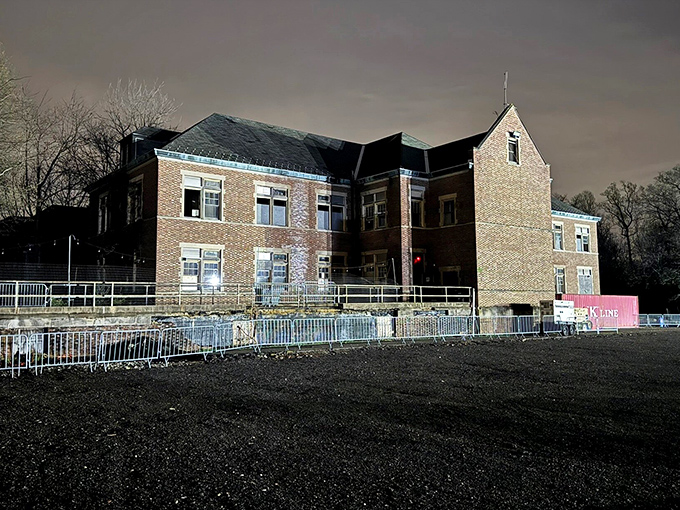 Twilight casts long shadows across the grounds, transforming the already imposing structure into something that could grace a classic horror film cover.