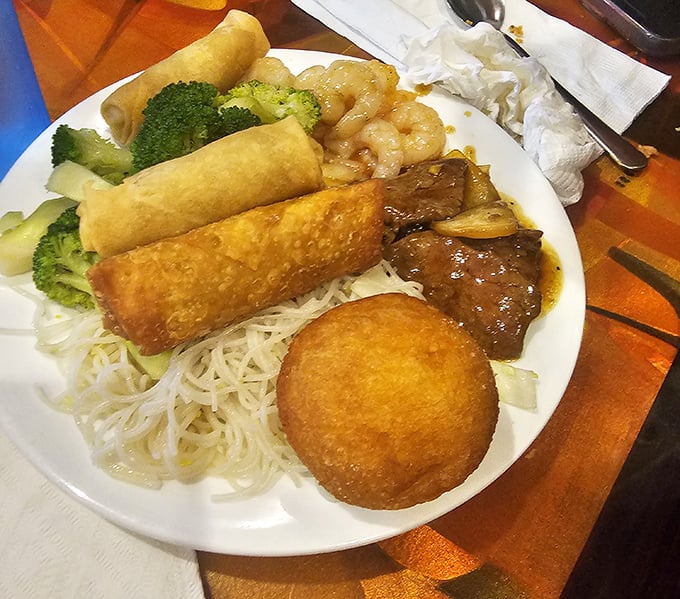 The beauty of buffet dining captured on one plate: Asian favorites, comfort foods, and fresh vegetables creating a personal feast.
