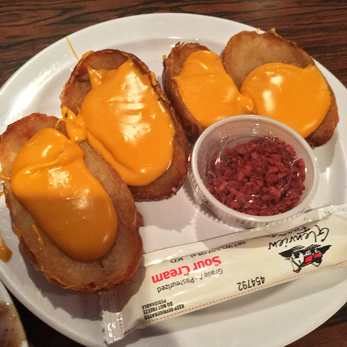 Potato skins wearing melted cheese like a royal robe, with bacon bits standing by for added decadence. Diet culture's kryptonite, served hot.