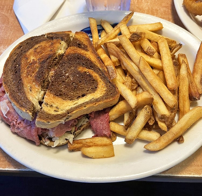 The Reuben on marble rye with golden fries standing at attention. A sandwich so perfect it makes you wonder why you ever order anything else.