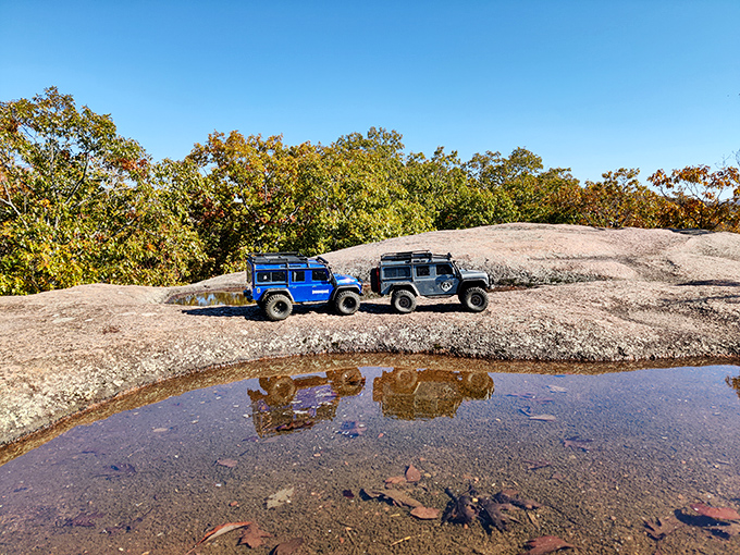 Off-road adventure meets prehistoric playground. These vehicles look tiny compared to the massive stone canvas they're parked upon.