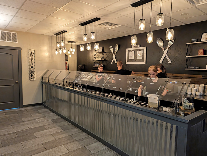 The salad bar area gleams under mason jar lights, where staff prepare to help you make questionable decisions about how much food you can actually eat.