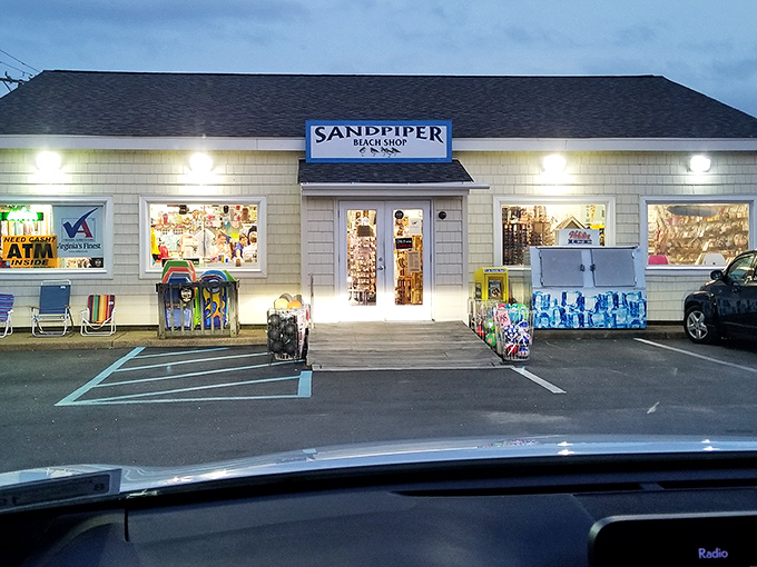 The Sandpiper Beach Shop glows at dusk, a beacon for those who've forgotten sunscreen, beach toys, or that third souvenir t-shirt nobody needs.