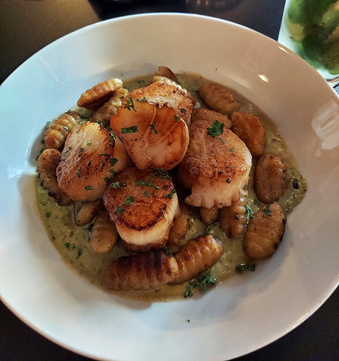 Perfectly seared scallops lounging in a savory broth with gnocchi&mdash;like pillowy life rafts in a sea of flavor.