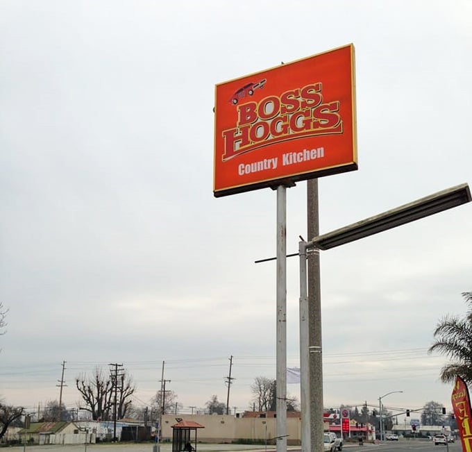 The roadside sign stands tall against the California sky, a bright orange promise of country cooking that's worth pulling over for.