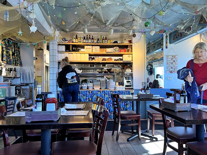 The open kitchen design lets you watch the seafood magic happen while fishing nets and twinkling lights create the perfect ambiance.