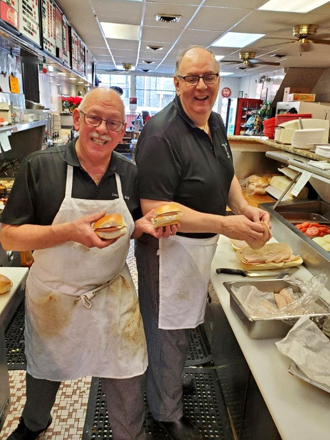 The sandwich artists at work, proudly displaying their creations. These are the hands that feed Norristown's sandwich cravings.
