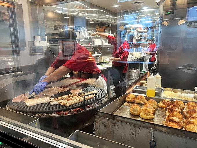 Behind the glass, culinary choreography unfolds as seafood meets mesquite. This is where the magic happens, folks.