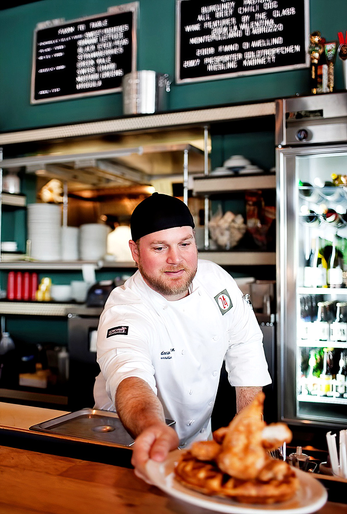 In the kitchen, culinary magic happens with practiced hands. The chef's focused expression says everything about the care behind each plate.