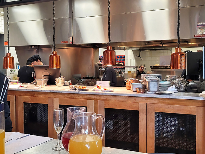 The open kitchen concept lets you watch culinary magic happen in real time. Those copper pendant lights aren't just stylish&mdash;they're spotlights for the star chefs.