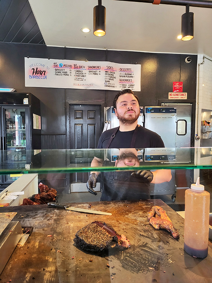 Barbecue is performance art, and this craftsman is center stage. The wooden cutting board has seen thousands of brisket slices and still wants more.