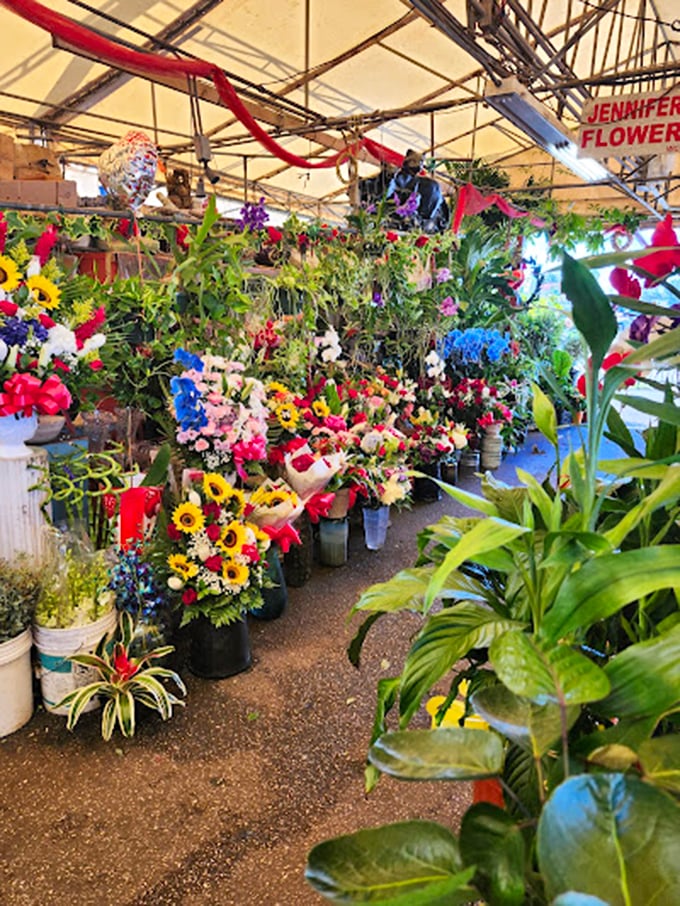 Nature and commerce blend seamlessly at the flower stalls, where potted plants and fresh-cut blooms create an impromptu jungle.