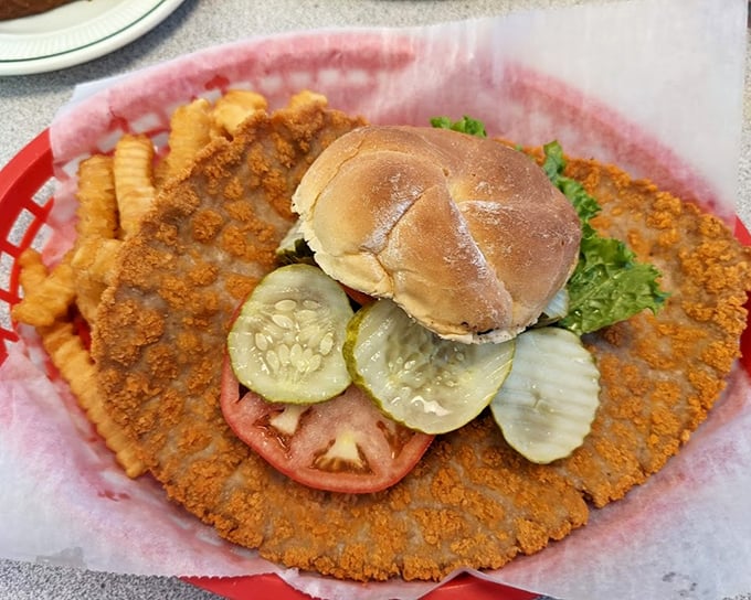 This isn't just a pork tenderloin&mdash;it's a crispy-edged monument to excess that makes the bun look like it's playing a supporting role.