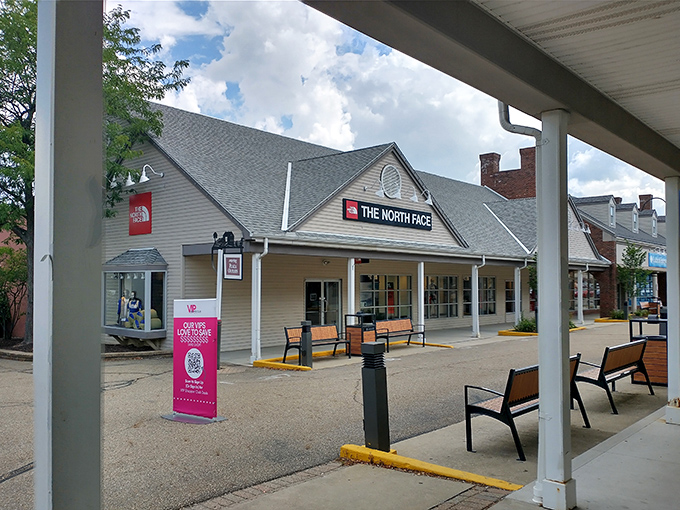 The North Face outlet beckons outdoor enthusiasts and fashion-conscious shoppers alike. Those benches outside are for partners contemplating their financial futures.