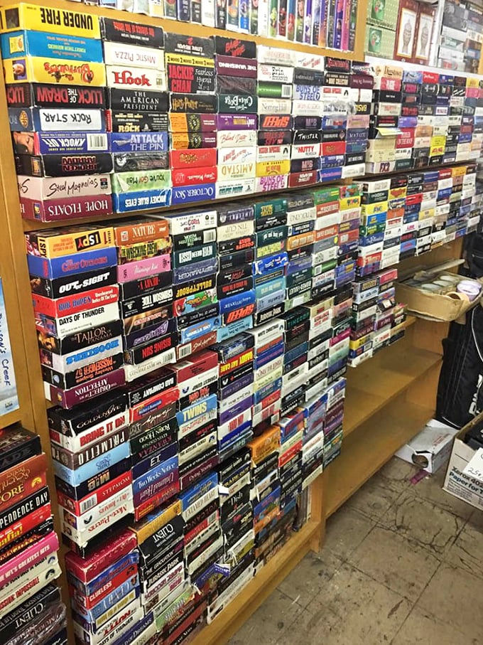 VHS tapes stacked like a physical Netflix from another era. Each spine represents someone's movie night from the days when "streaming" meant something was wet.