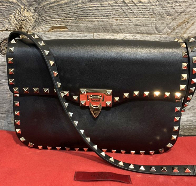 The Valentino Rockstud crossbody—where edgy meets elegant—sits regally on its display, studs catching light like tiny fashion exclamation points.