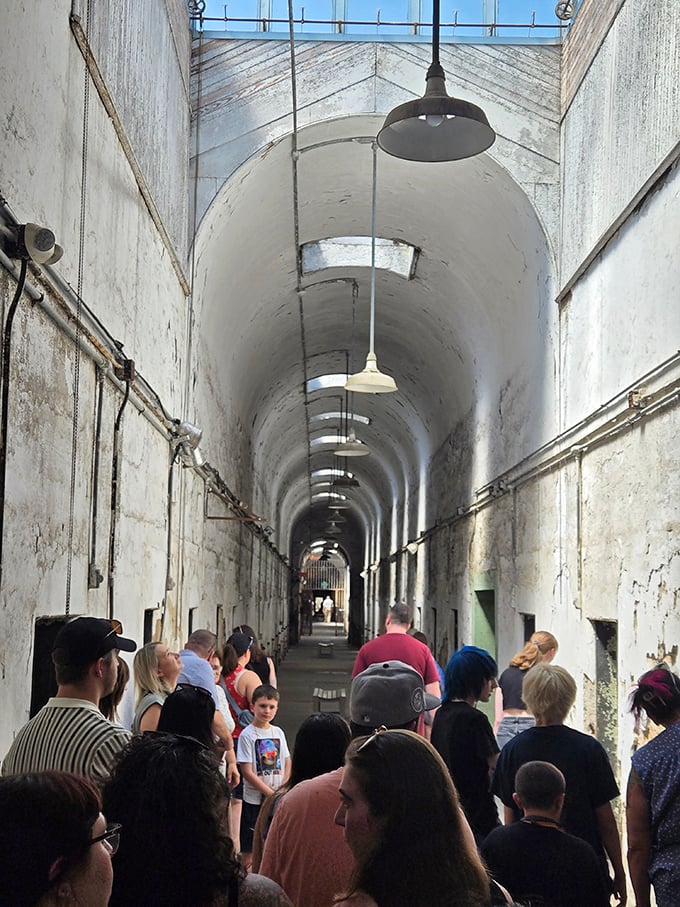 Tour groups shuffle through the same corridors once walked by America's most notorious criminals. The white walls amplify every whisper and footstep.