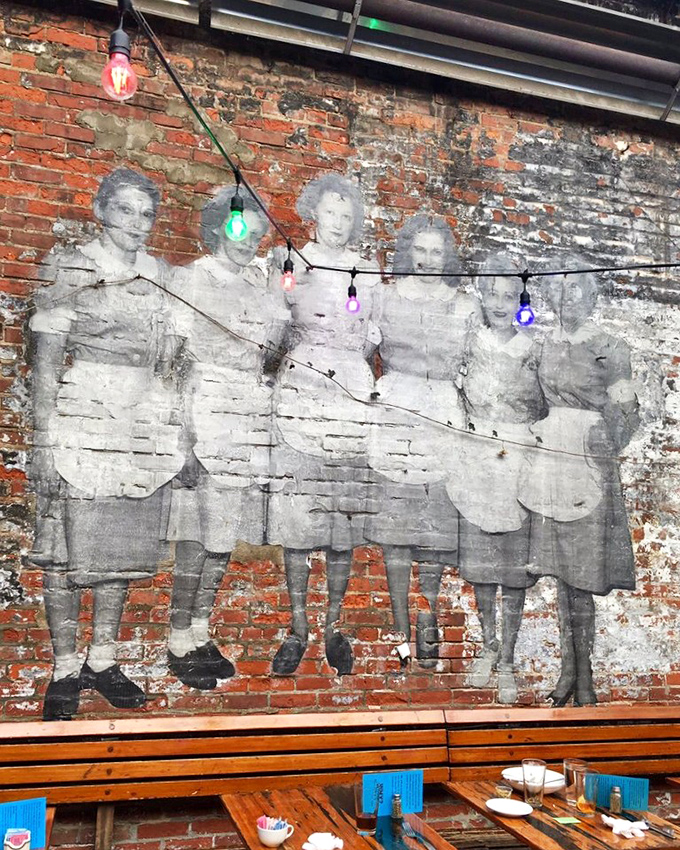 History literally written on the walls. These faded faces from another era watch over diners, string lights adding a touch of whimsy to the past.