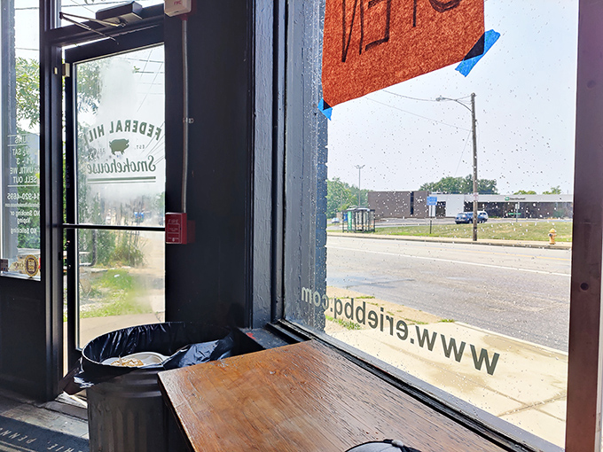The window seat offers prime people-watching: those arriving with anticipation and those leaving with the satisfied glow of barbecue bliss.