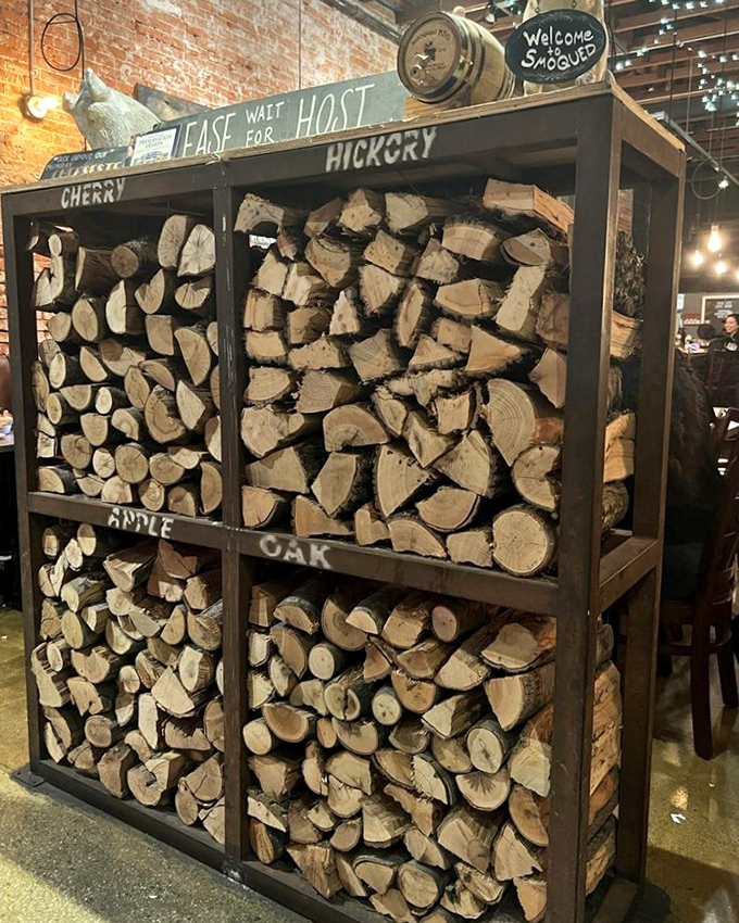 This wood display isn't decoration - it's the fuel that transforms ordinary meat into extraordinary memories through patient smoking.
