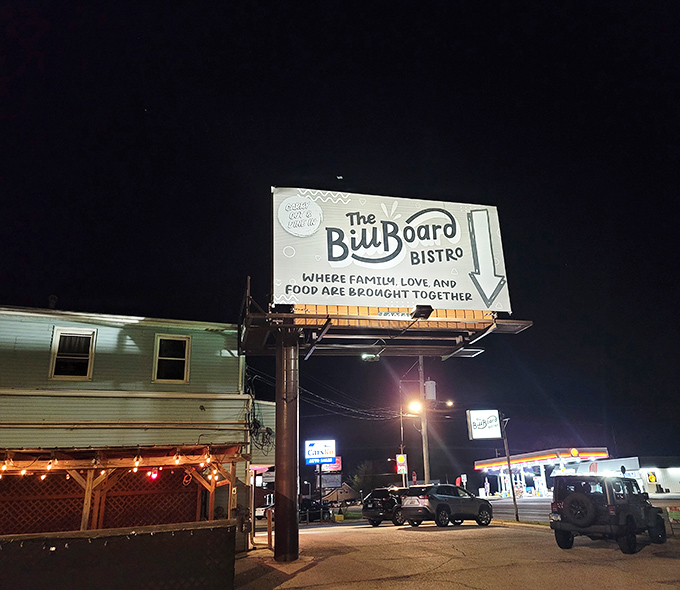 Under the night sky, the illuminated sign serves as a beacon for hungry travelers, promising comfort food salvation just steps away.