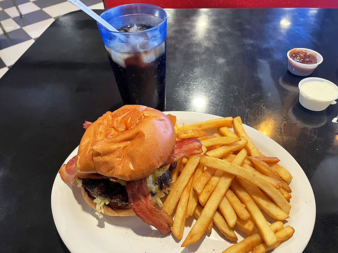 The bacon cheeseburger and fries &ndash; a classic American duet performing their greatest hits on a pristine white plate.