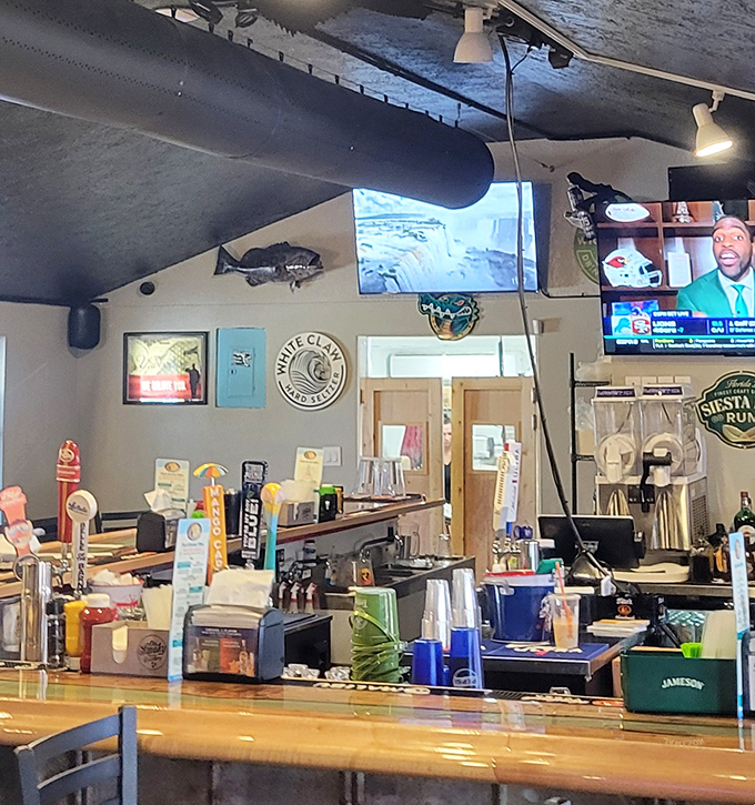 The bar stands ready for thirsty travelers, with fishing memorabilia and cold drinks waiting to wash down that perfect cheeseburger.