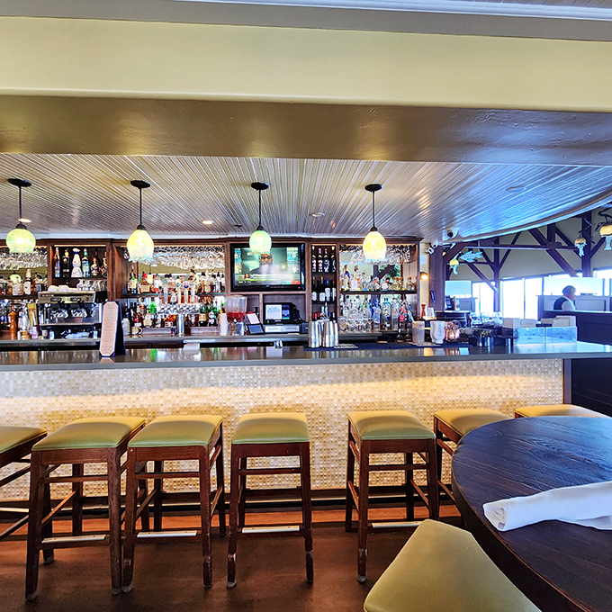 The bar gleams with promise, bottles standing at attention like soldiers ready to serve in the battle against sobriety. Those pendant lights add just the right glow.