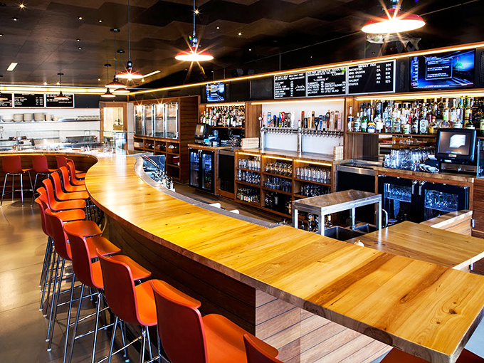 The bar area combines warm wood with sleek design elements, creating the perfect perch for oyster slurping and people watching in equal measure.