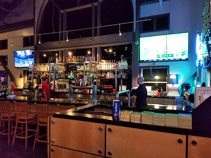 The bar area serves as command central, where drinks flow and sports fans gather to debate games while waiting for their numbered orders.
