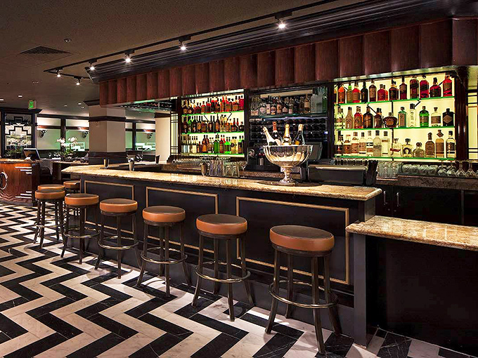 The bar gleams with amber-lit bottles like a library of liquid treasures, each promising its own unique story and happy ending.