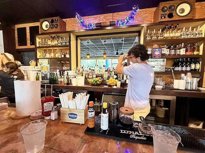 Behind the bar, bottles line up like soldiers ready for cocktail duty. The warm wood and amber lighting create a space where "just one drink" becomes three.