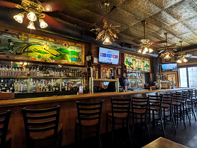 The bar where strangers become friends and friends become family, beneath stained glass that's witnessed countless toasts and tales.