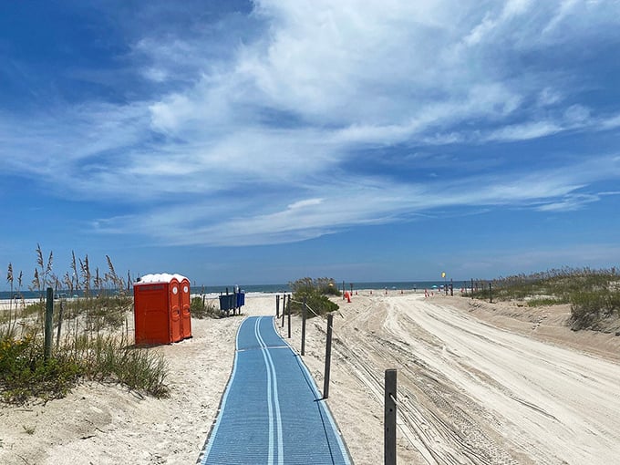 The beach access path curves toward endless possibilities, that distinctive blue walkway leading to the kind of day that doesn't need Instagram filters.