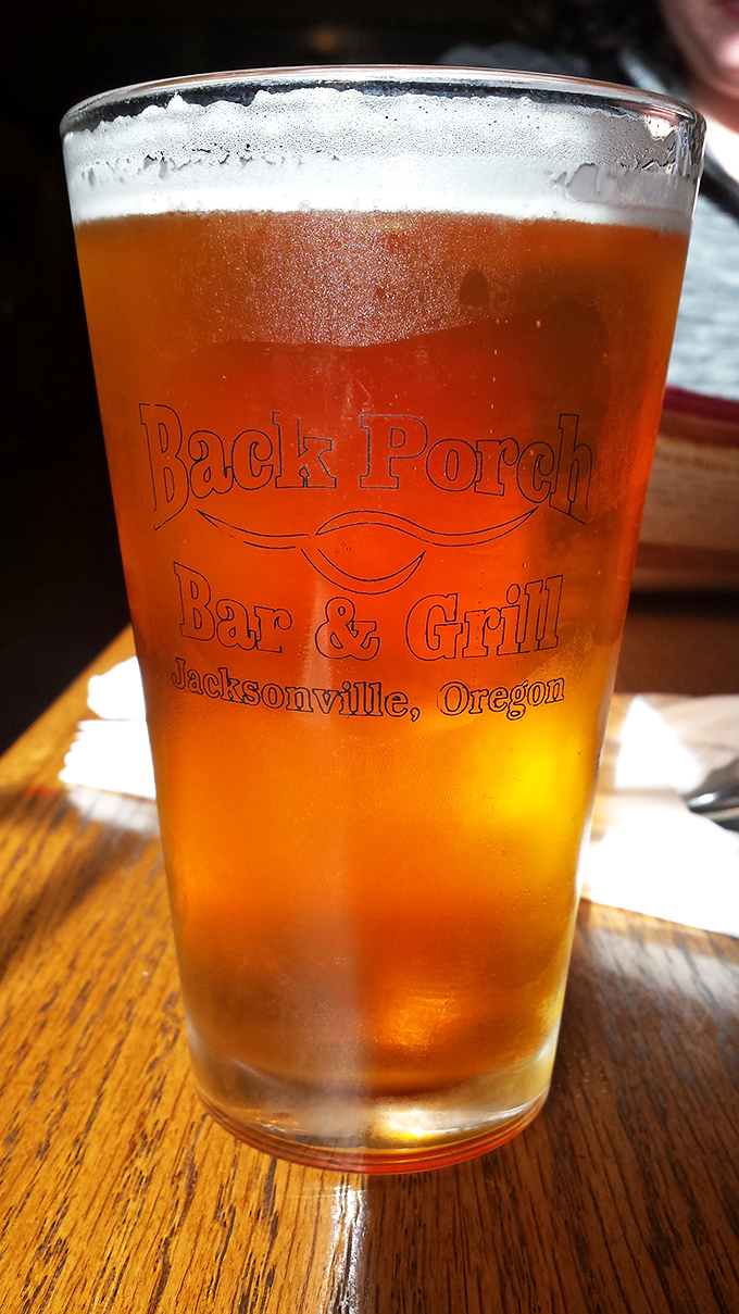 A perfectly poured local brew in custom glassware&mdash;because great barbecue deserves an equally thoughtful beverage companion.