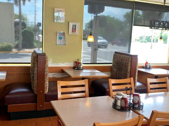 A glimpse of booth seating where countless conversations have unfolded over plates of eggs and pancakes. The condiment caddy stands ready for action.