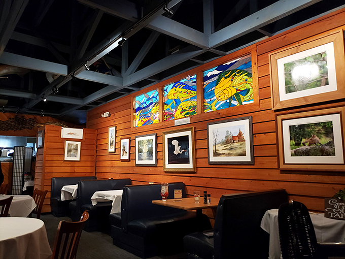 Cozy booths beneath colorful stained glass create the perfect backdrop for both intimate conversations and enthusiastic food sharing.